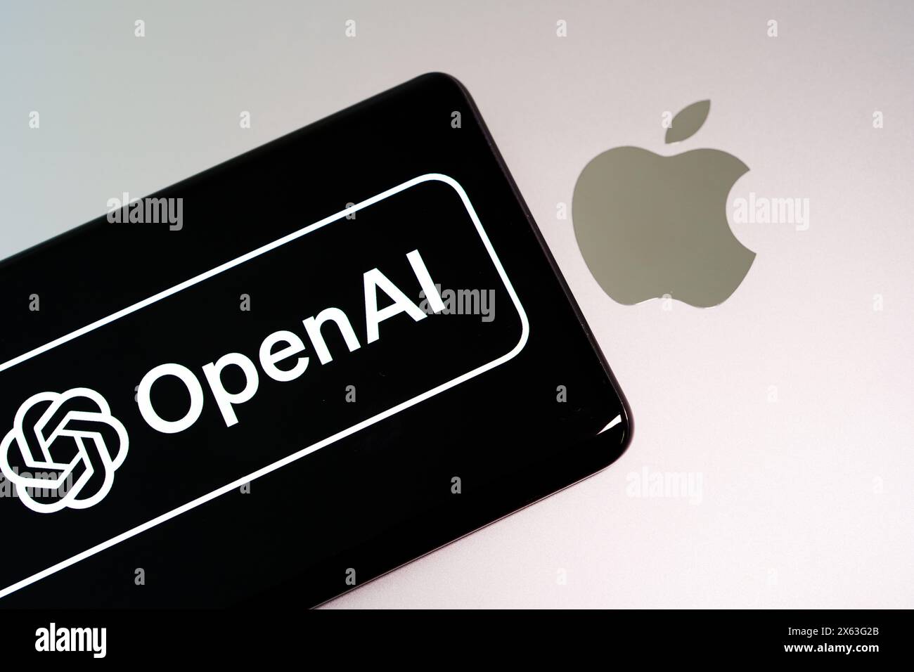 Apple laptop with smartphone on top having OpenAI Logo. Concept for ...