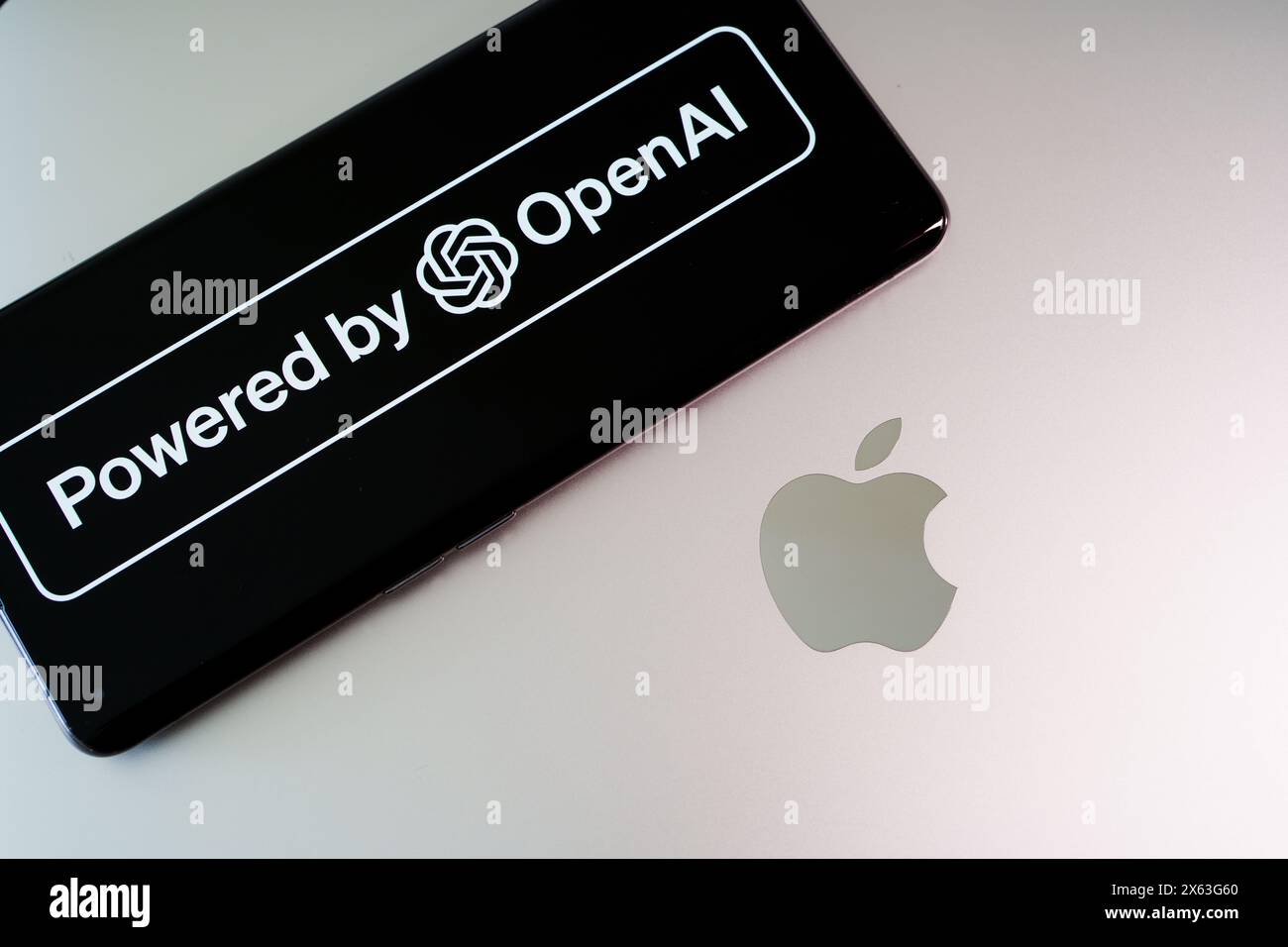Apple laptop with smartphone on top having OpenAI Logo. Concept for ...