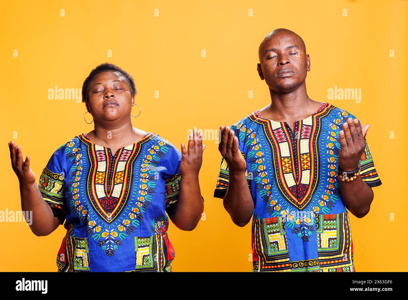 African american couple praying and asking blessing while posing with ...