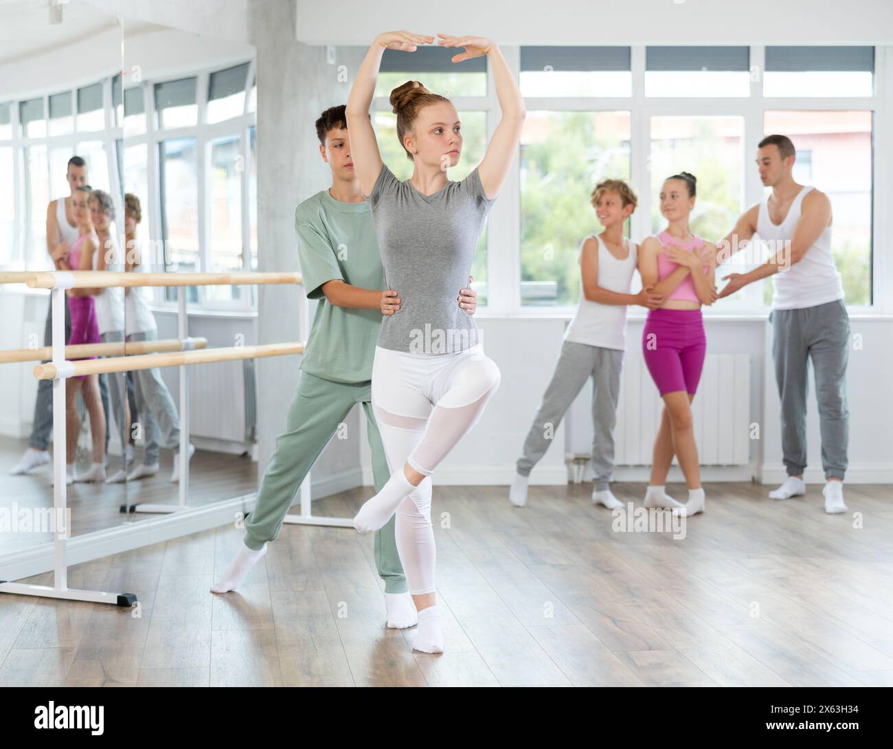 Teenage girl and boy practicing ballet positions in pair in dance ...