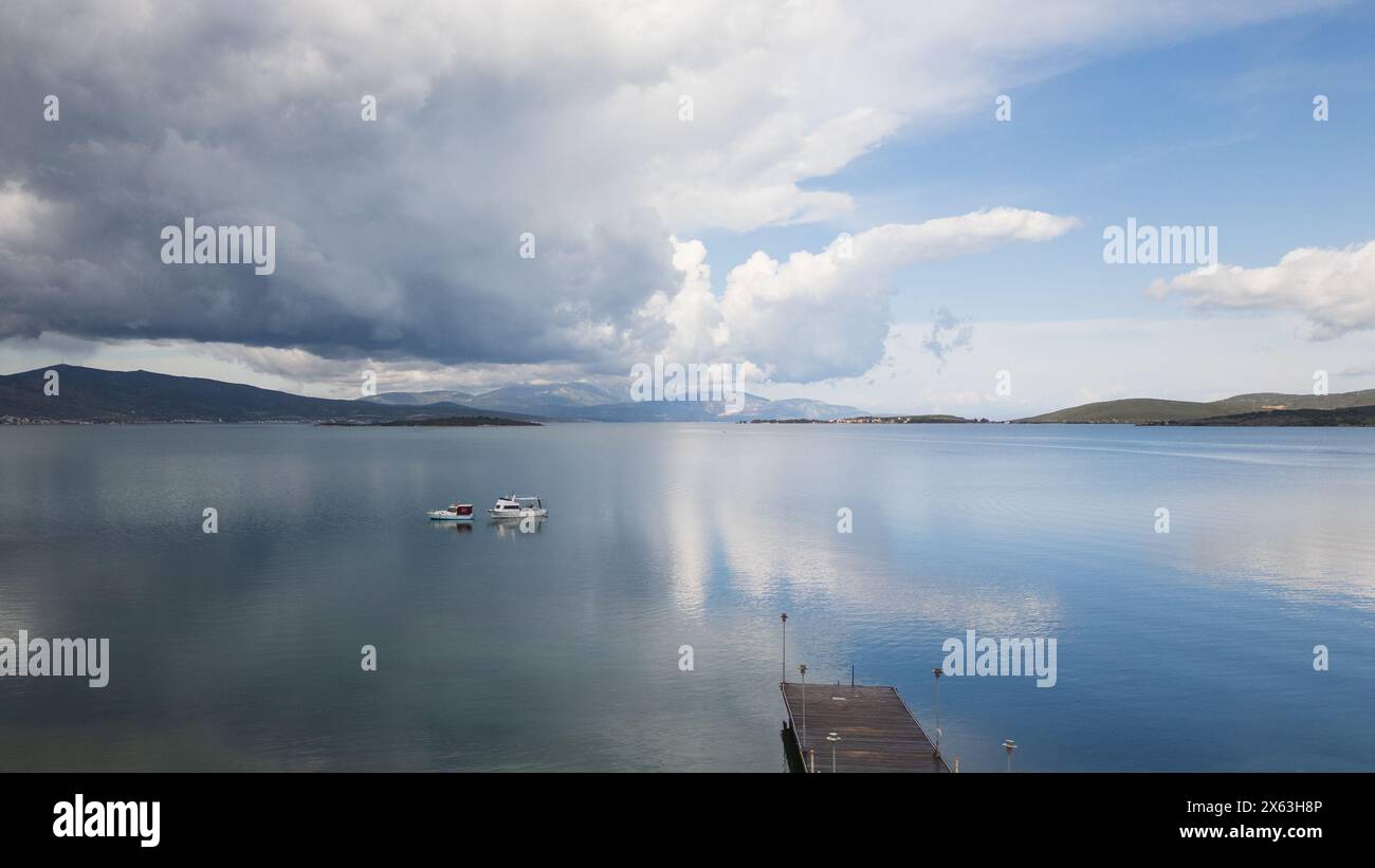A dock on a lake under a cloudy sky, creating a natural landscape Stock ...