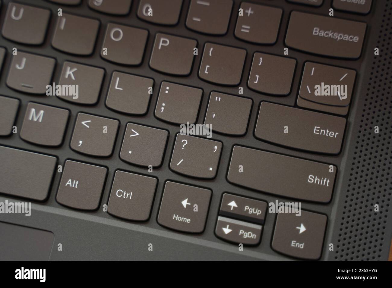 A detailed view of a computer keyboard with a mouse placed next to it ...