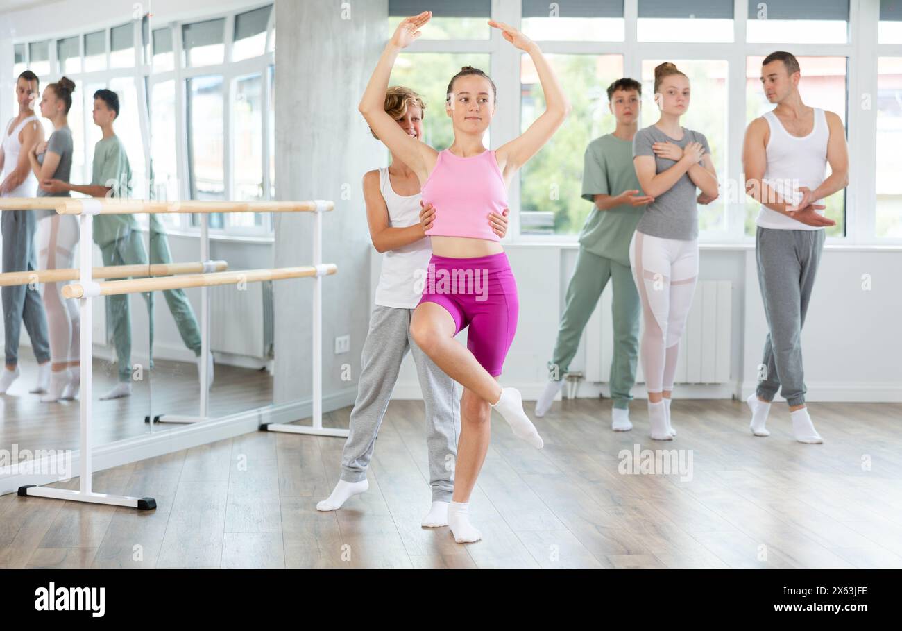 Teenage girl and boy practicing ballet positions in pair in dance ...