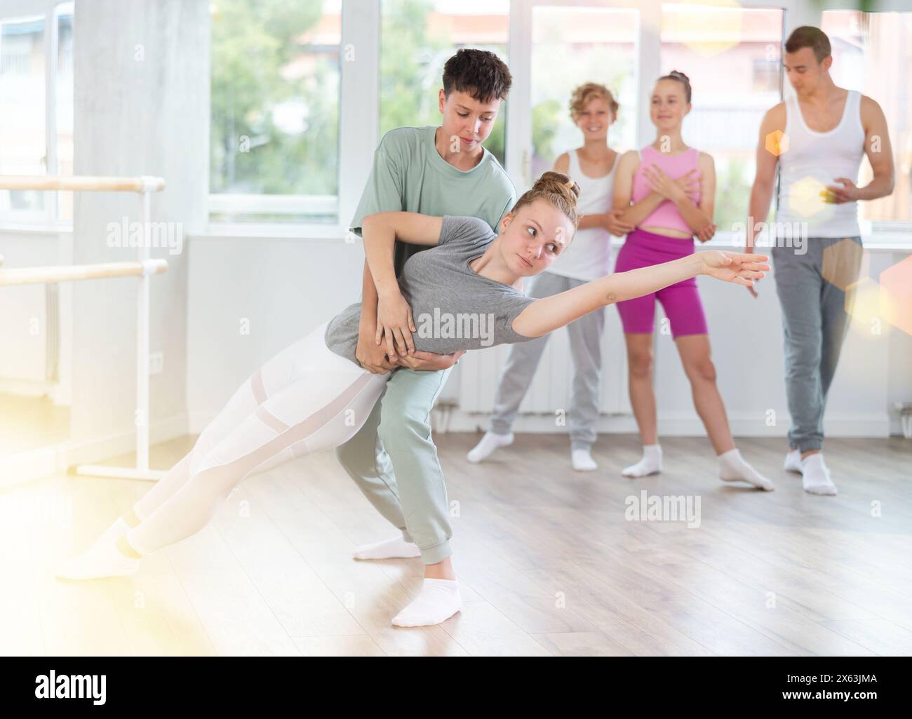 Teenage girl and boy practicing ballet positions in pair in dance ...