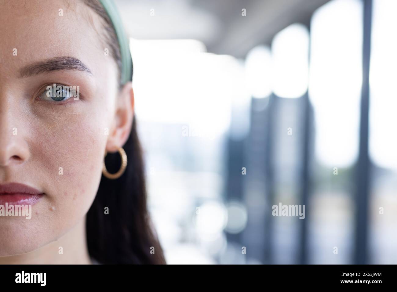 In modern office, young Caucasian female wearing green headband ...