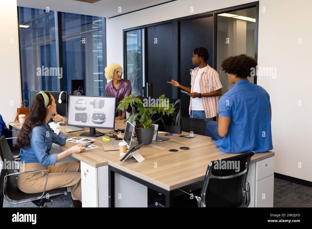 In modern office, a diverse young team discussing work, African ...