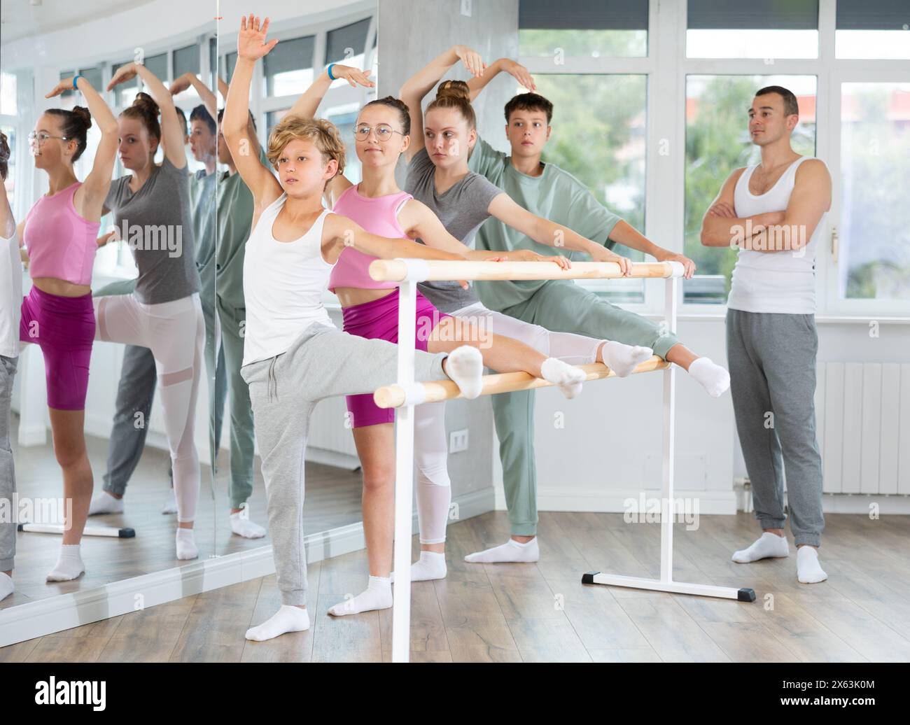 Ballet pose grand batman - girls and boys at a choreography lesson are ...