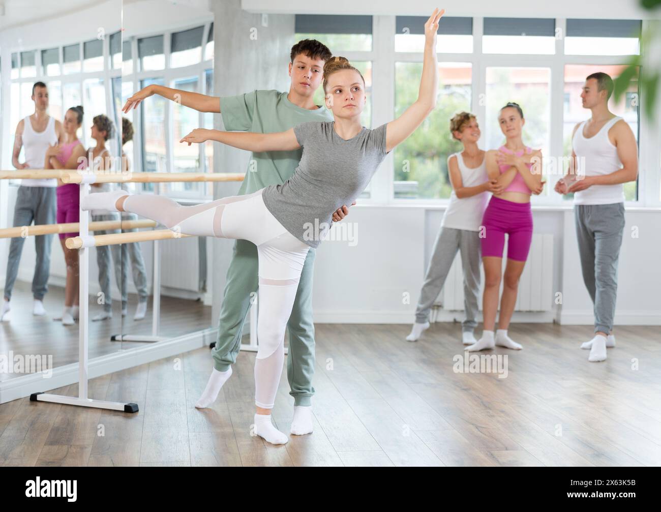 Ballet studio - teenagers girls and boys learn ballet movements in ...