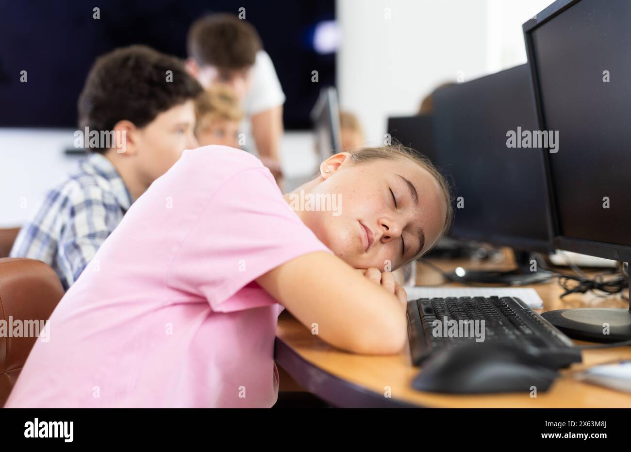 Tired female schoolgirl fell asleep on computer keyboard in class Stock ...