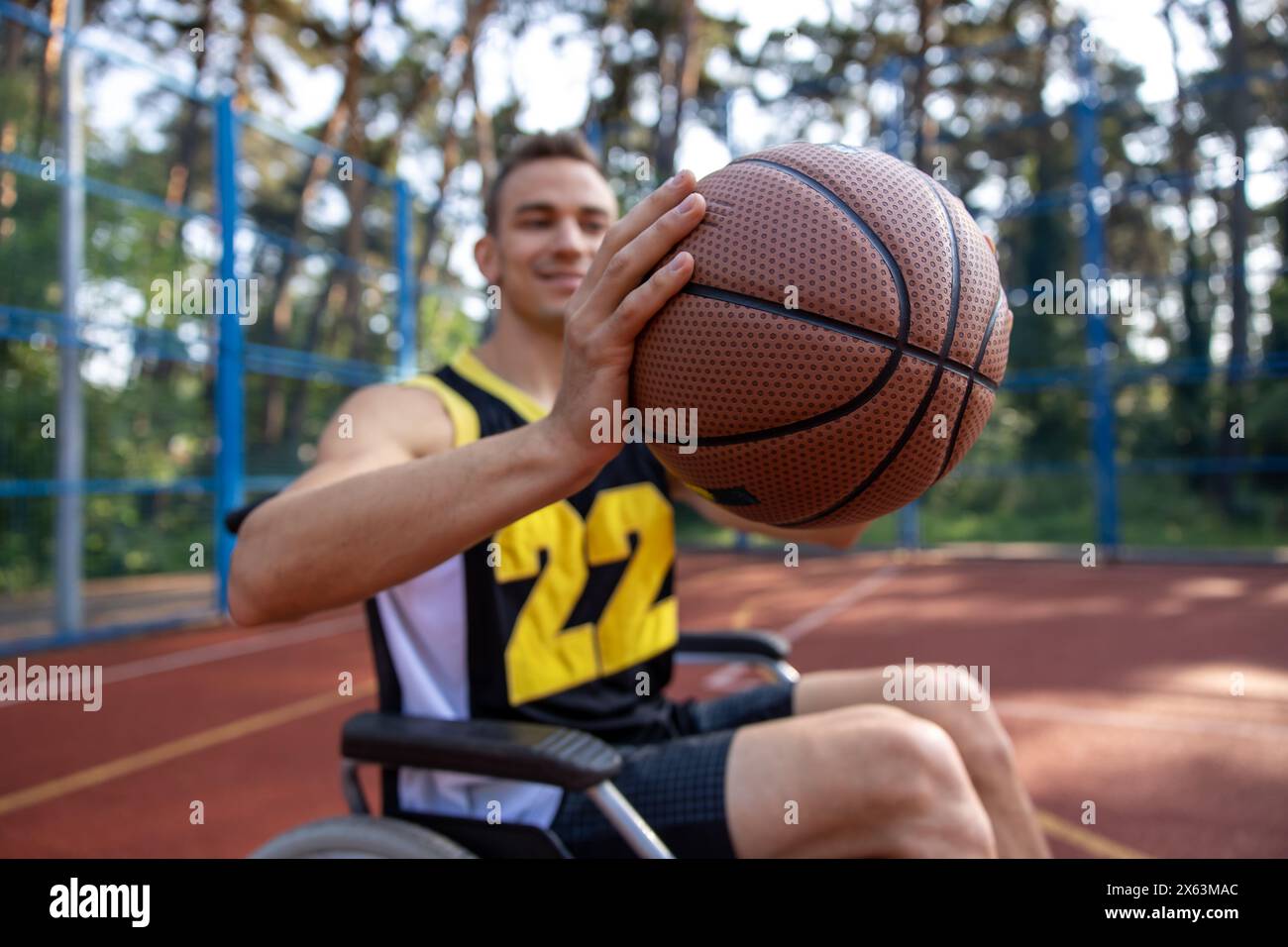Young guy athlete having disability in wheelchair having basketball ...