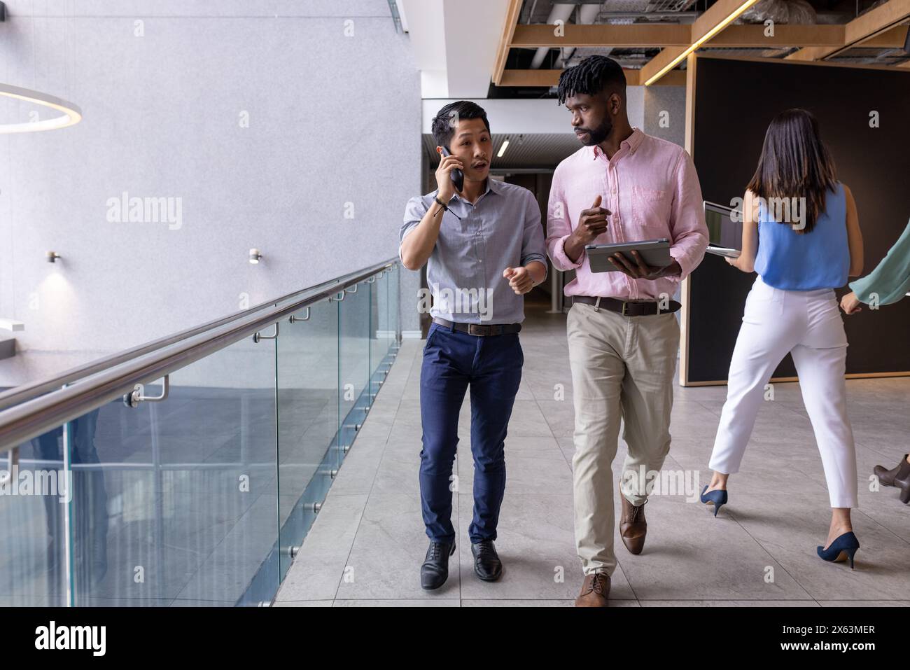 Diverse office team at office, walking and talking, wearing casual ...