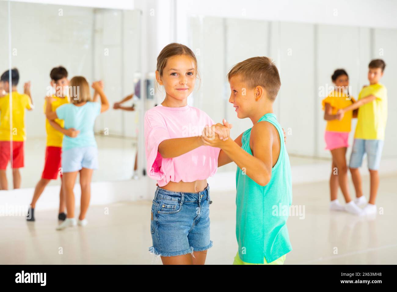 Preteen children learning to dance waltz in pairs in choreography class ...