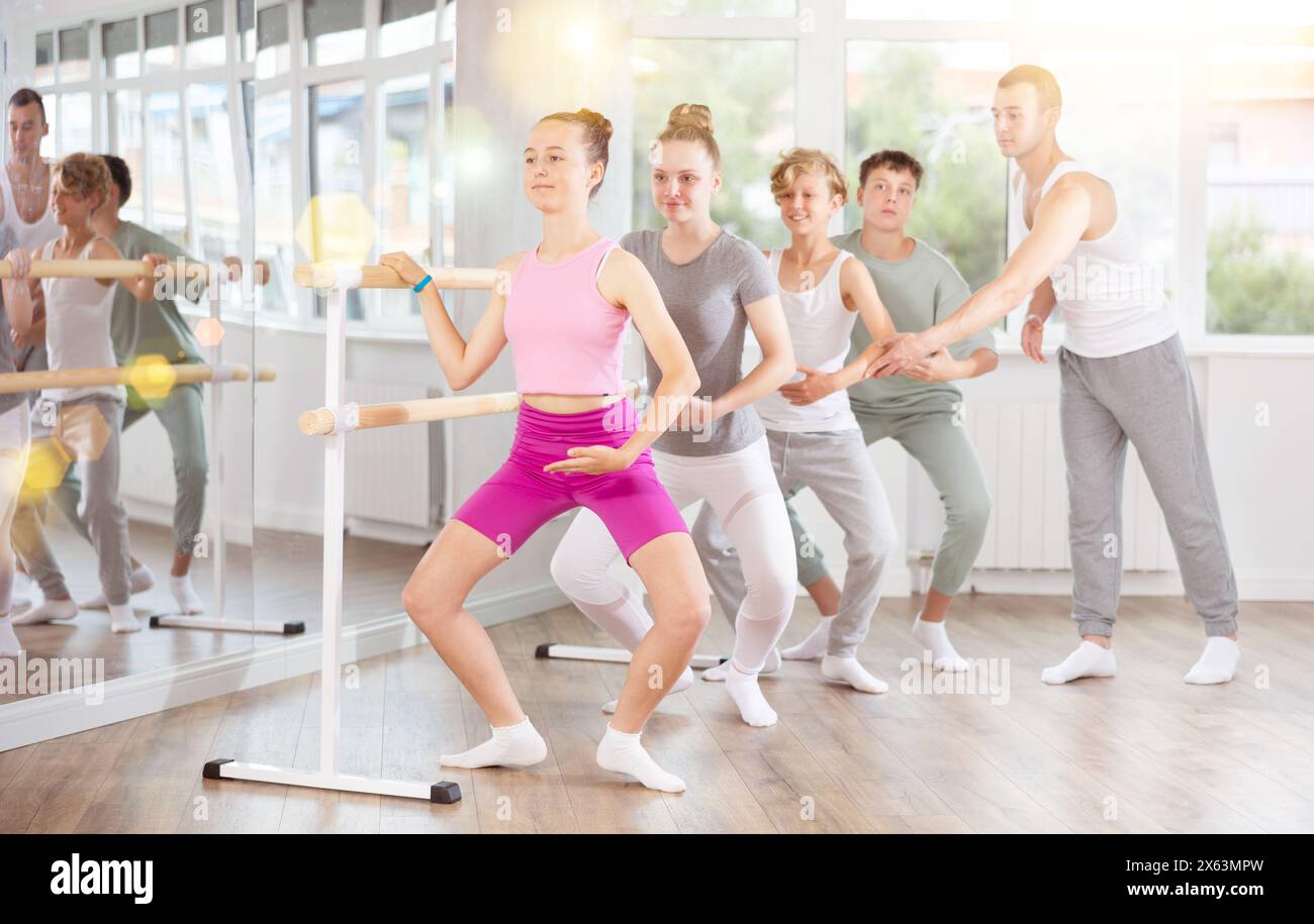 Teenage girl practicing plie position of ballet during choreography ...