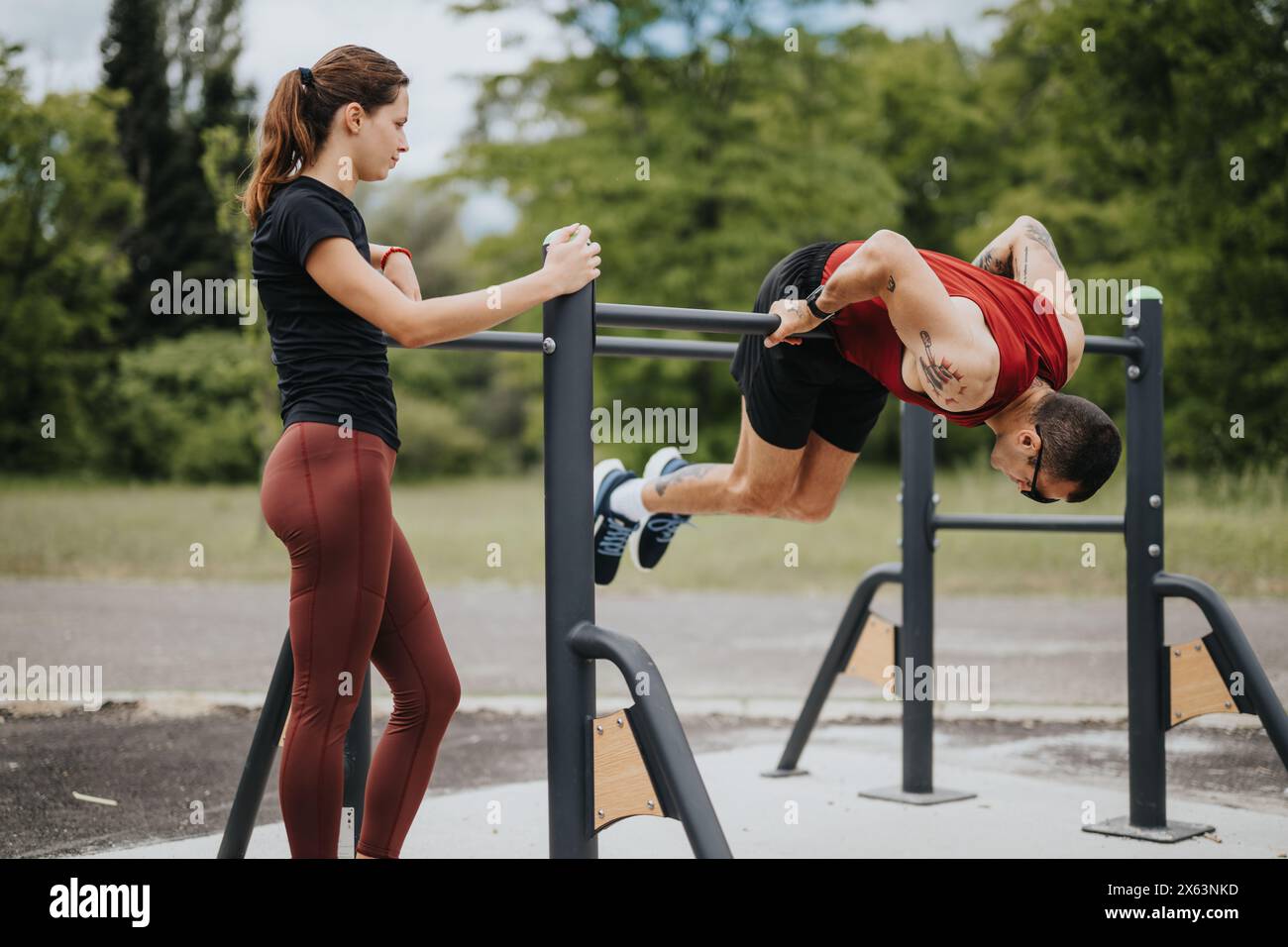 Fitness duo working out at an outdoor gym, performing strength ...