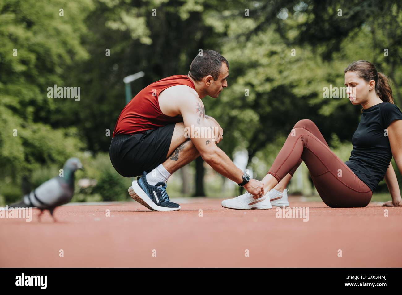 Caring man assists injured woman on running track, ensuring her comfort ...