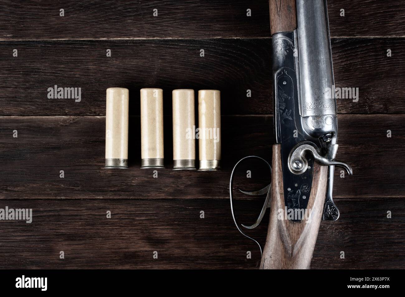 double barreled side shotgun with paper cartridges on wooden table ...
