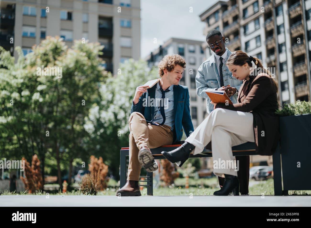 Diverse business team strategizing in an urban park setting Stock Photo ...