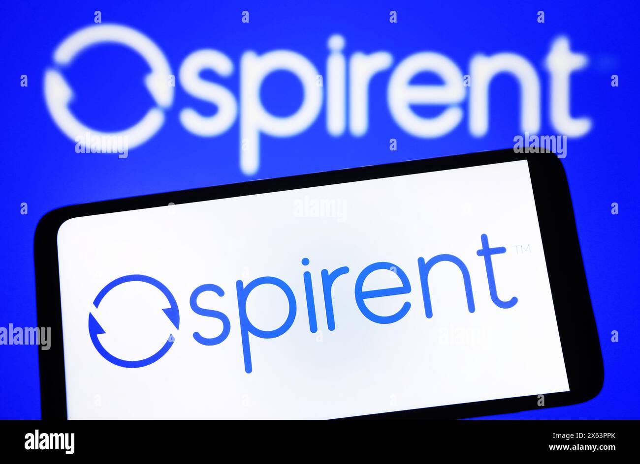 In this photo illustration, Spirent Communications plc logo is seen on a smartphone and on a pc ...