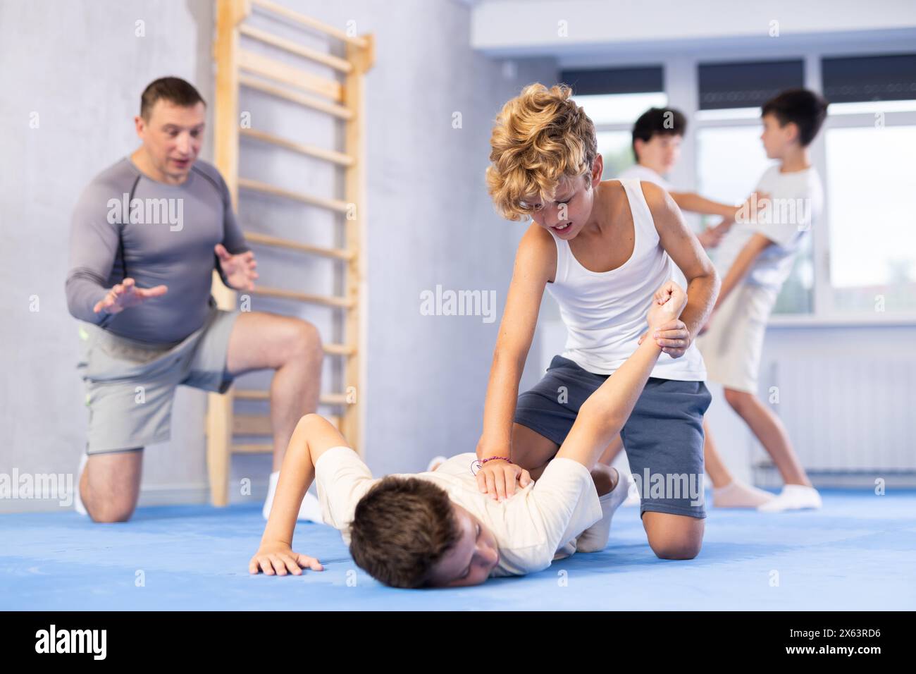Teens practicing armlock in training bout during self defence course ...