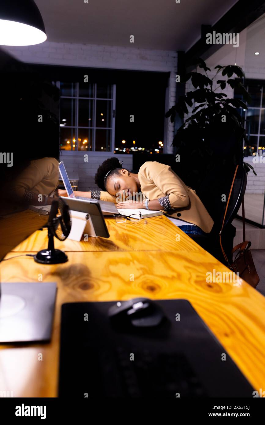 Working late, African American businesswoman resting head on desk Stock ...