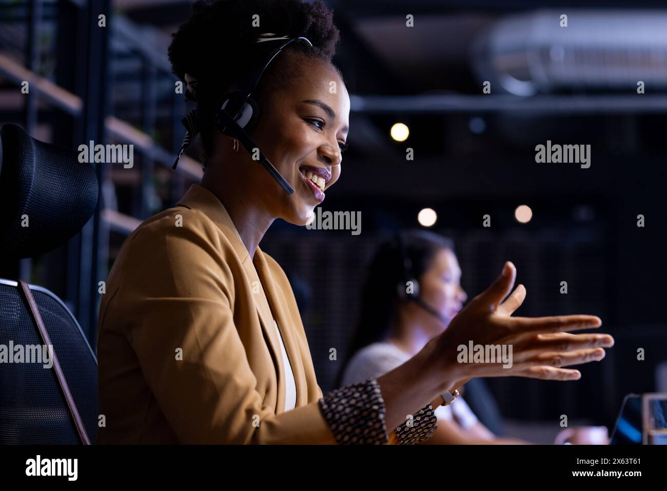 At office, diverse female colleagues wearing headsets, discussing work ...