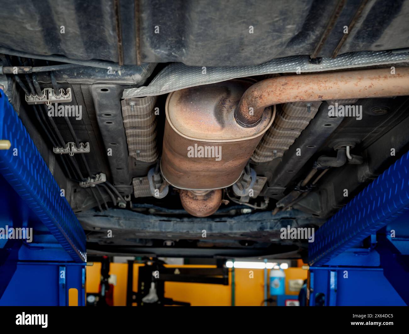 Bottom view of exhaust pipe under the car while lifted vehicle check-up ...