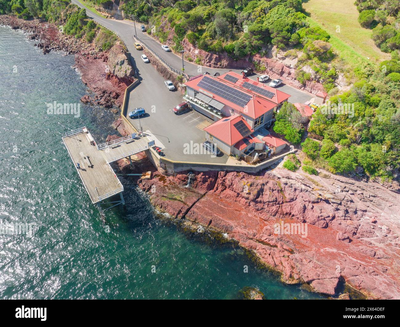 Aerial view of raised pier and carpark over a rocky coastline at ...