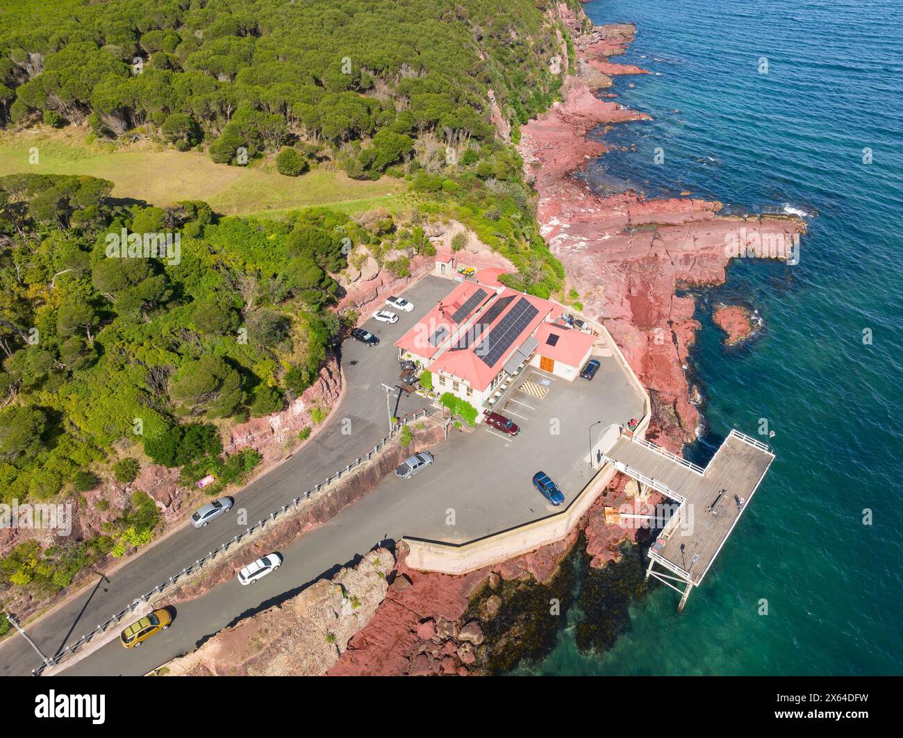 Aerial view of raised pier and carpark over a rocky coastline at ...