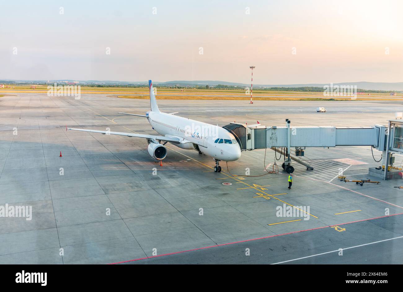 Passenger plane on the airfield connected to walkway.The gate sleeve is ...