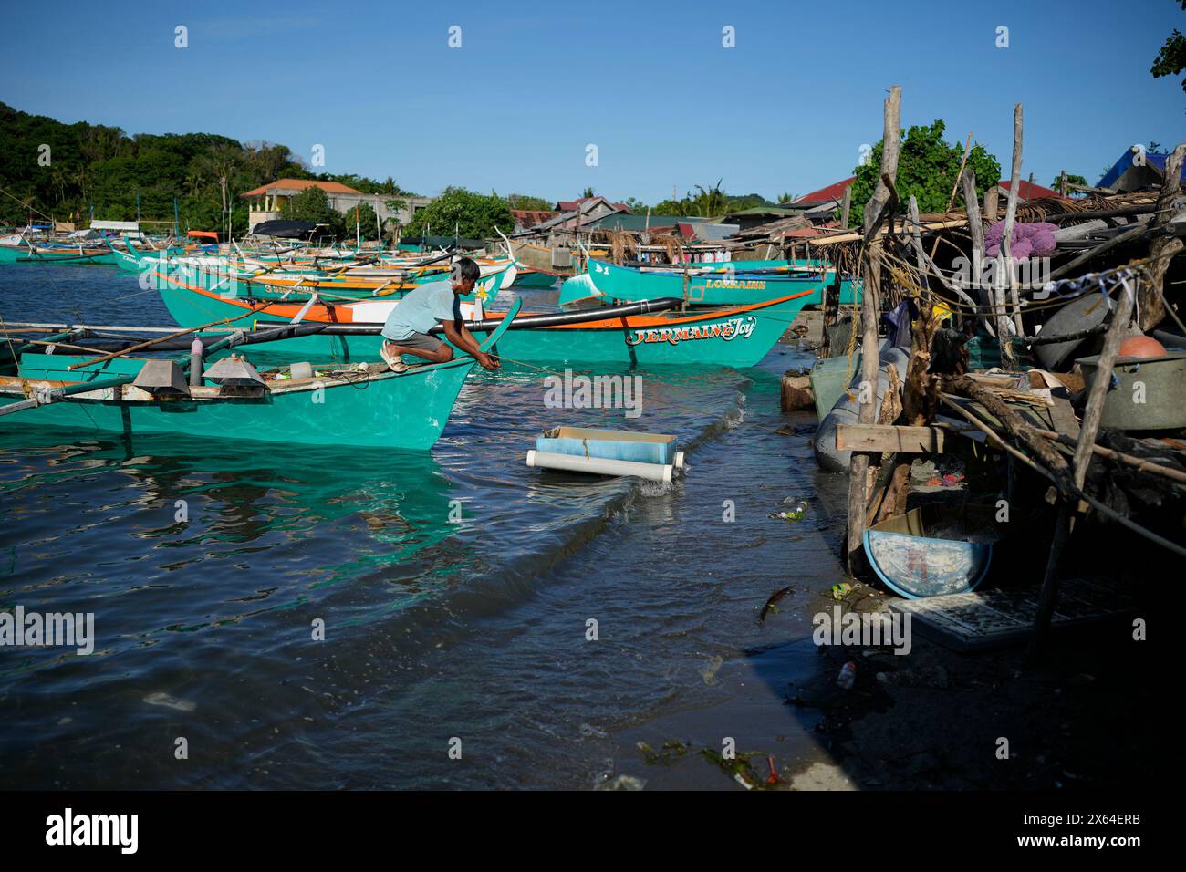 A man prepares his boat at the port of the coastal town of Santa Ana ...