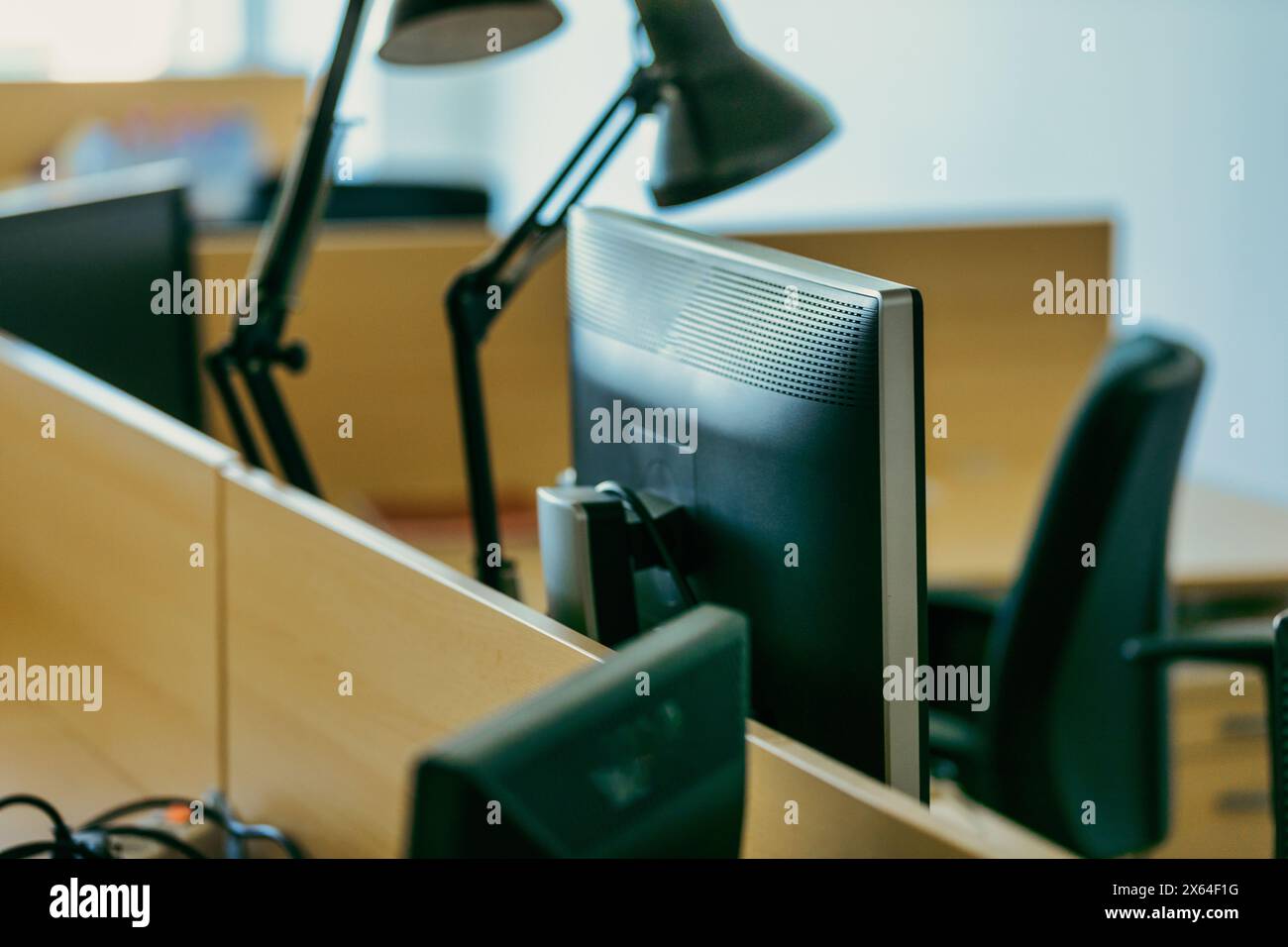 Modern office workspace featuring a sleek monitor, twin desk lamps, and ...