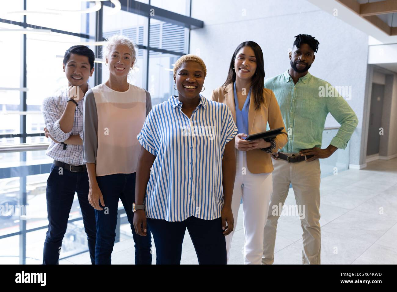 Diverse team standing together at office, smiling Stock Photo - Alamy
