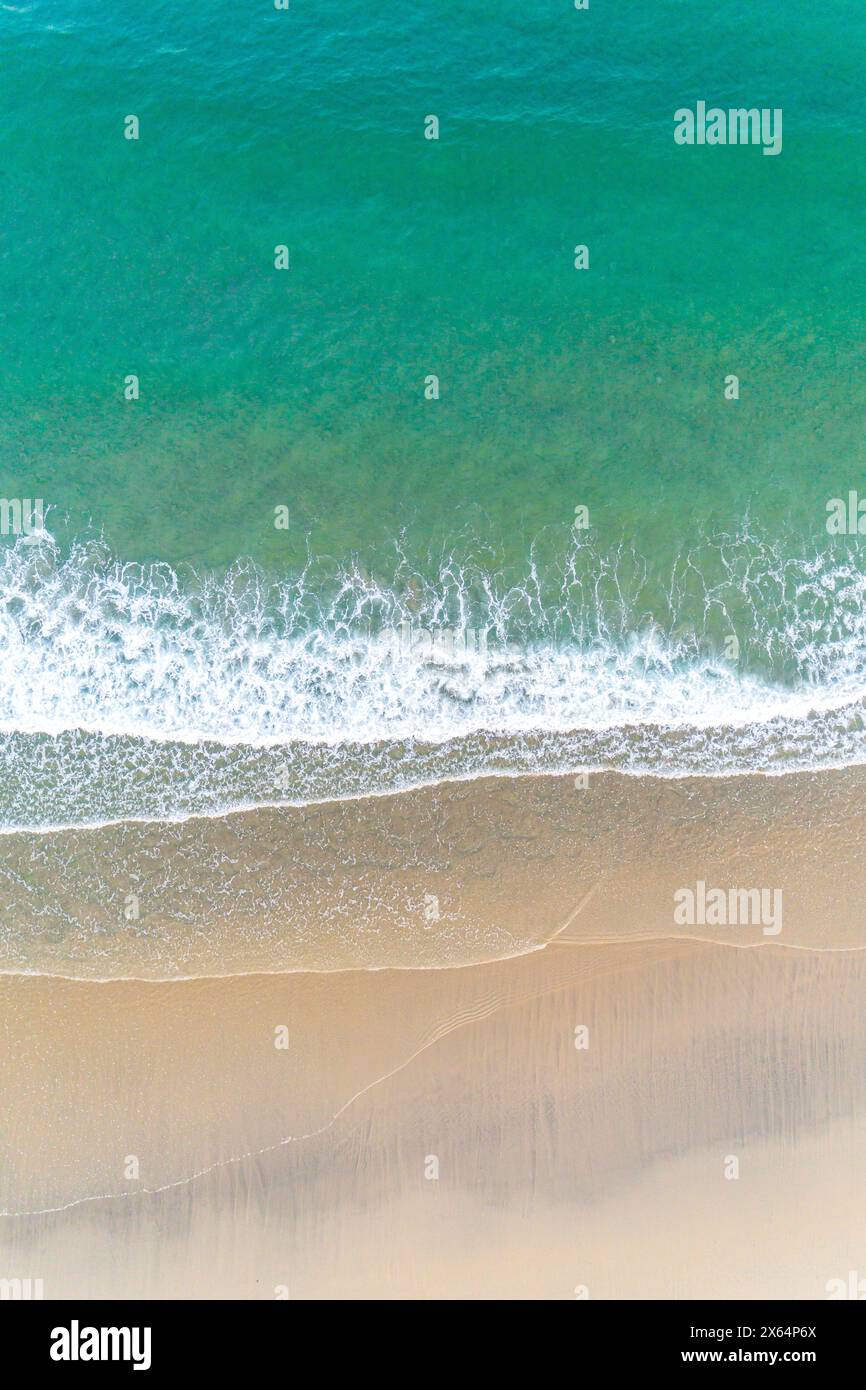 shore of an empty beach at dawn, turquoise water. Aerial overhead view ...
