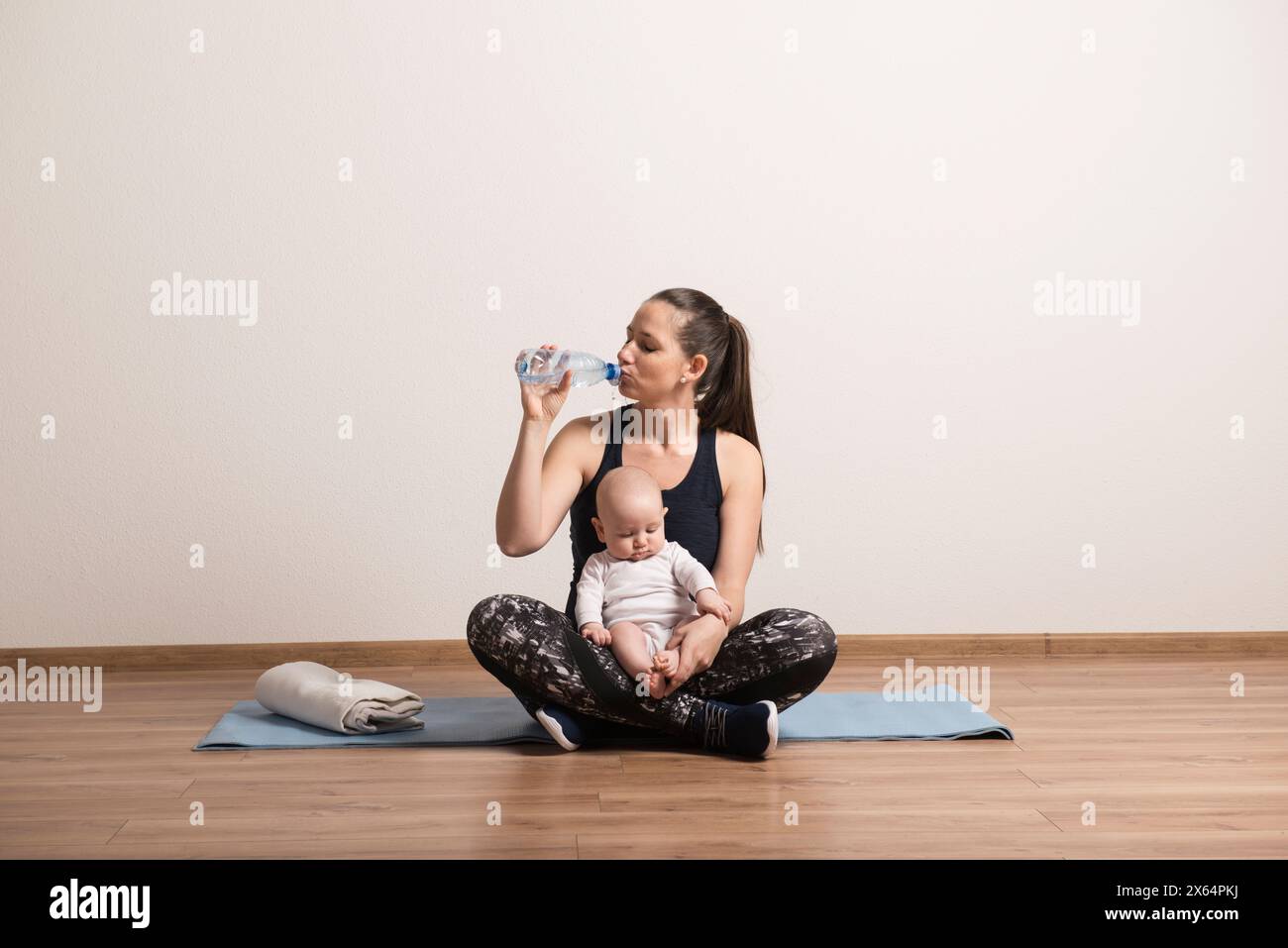 Woman drinkng water after home exercise for mother and baby, mommy and ...