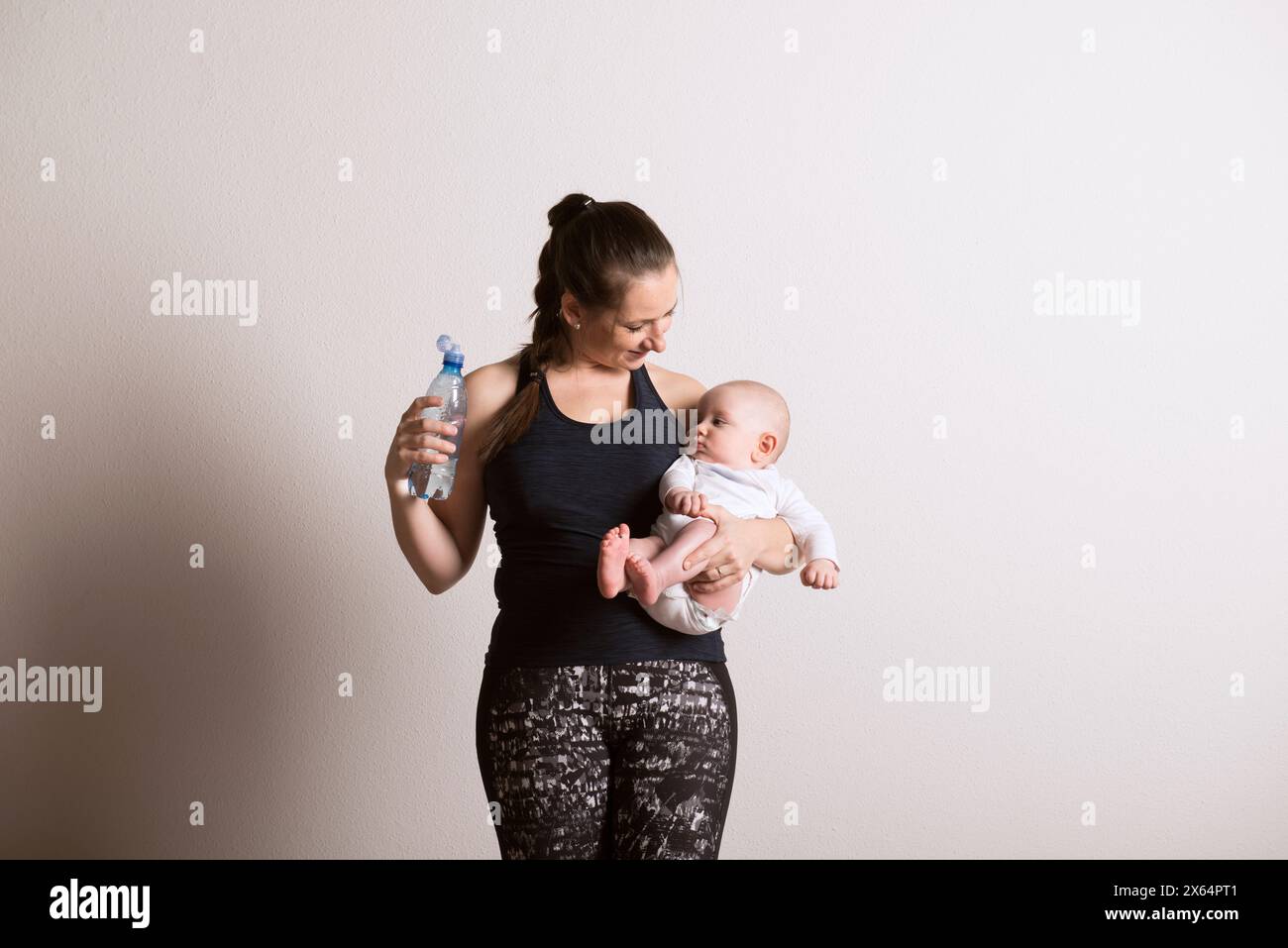 Woman drinkng water after home exercise for mother and baby, mommy and ...