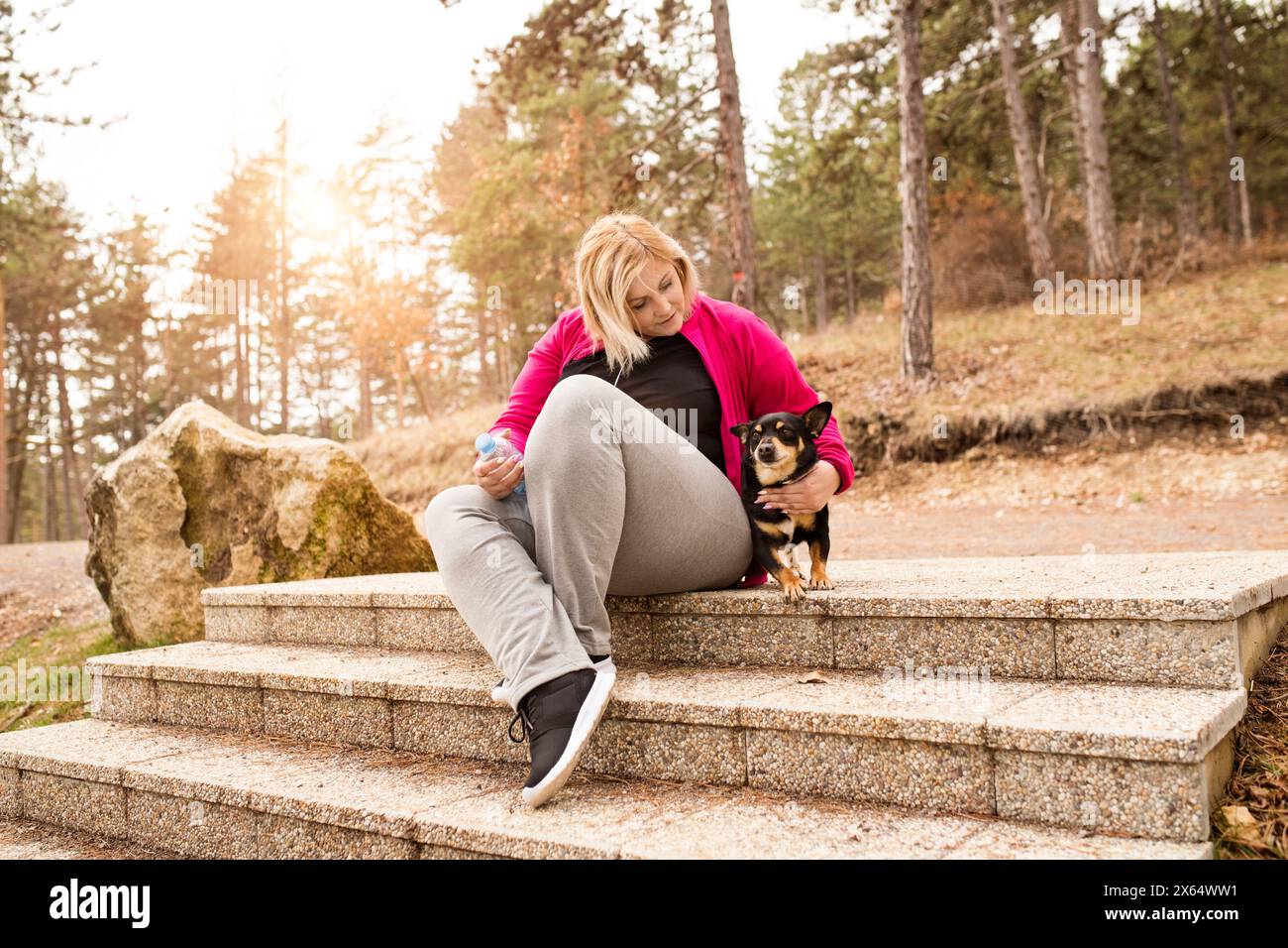 Overweight woman running with dog in nature, resting after workout ...
