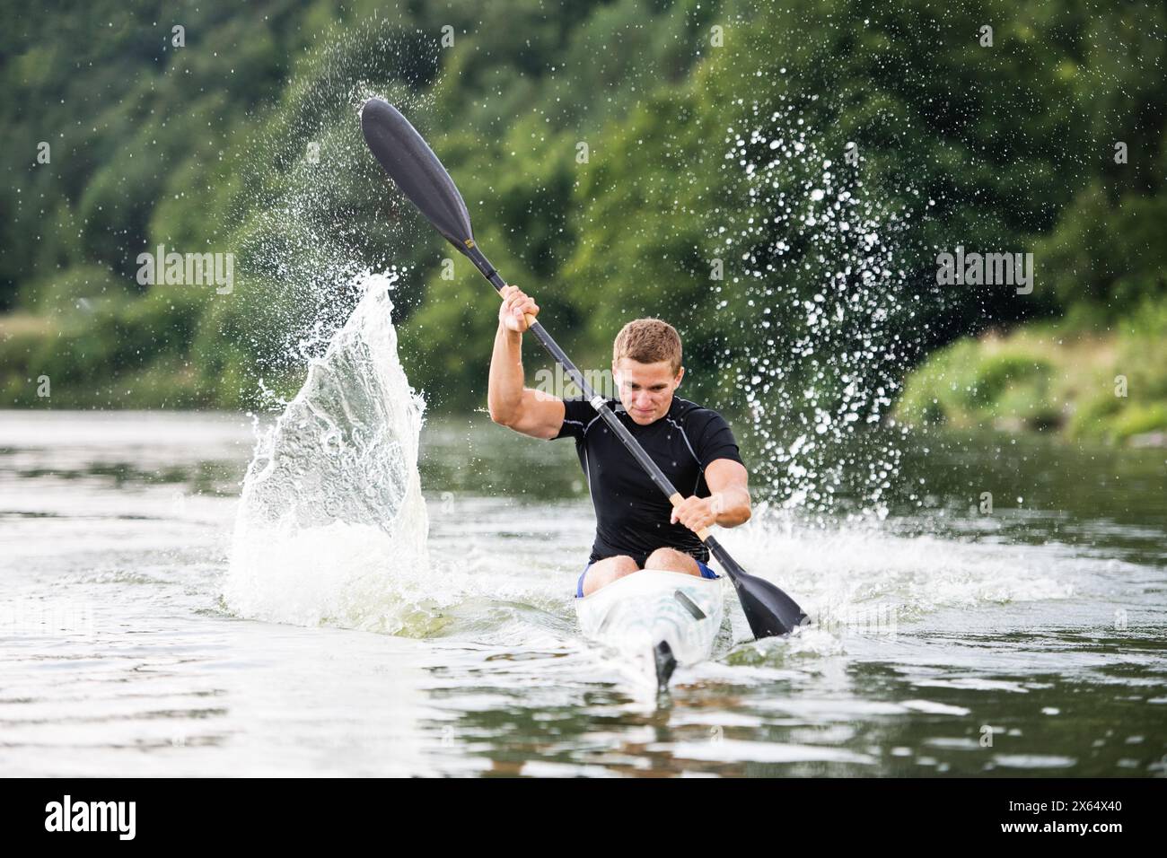 Canoeist man sitting in canoe paddling, in water. Concept of canoeing ...