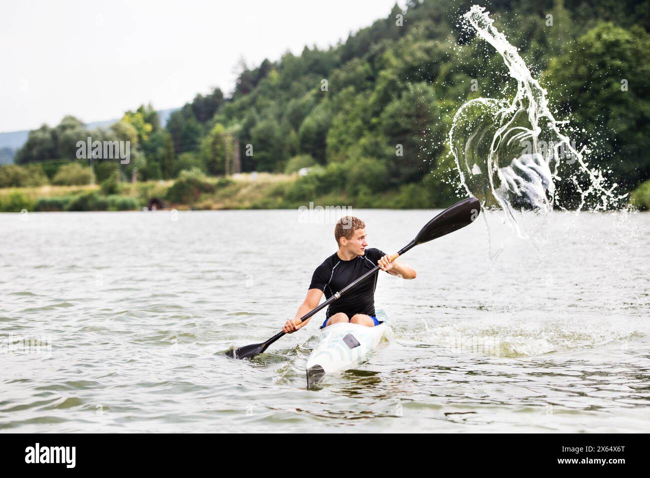 Canoeist man sitting in canoe paddling, in water. Concept of canoeing ...