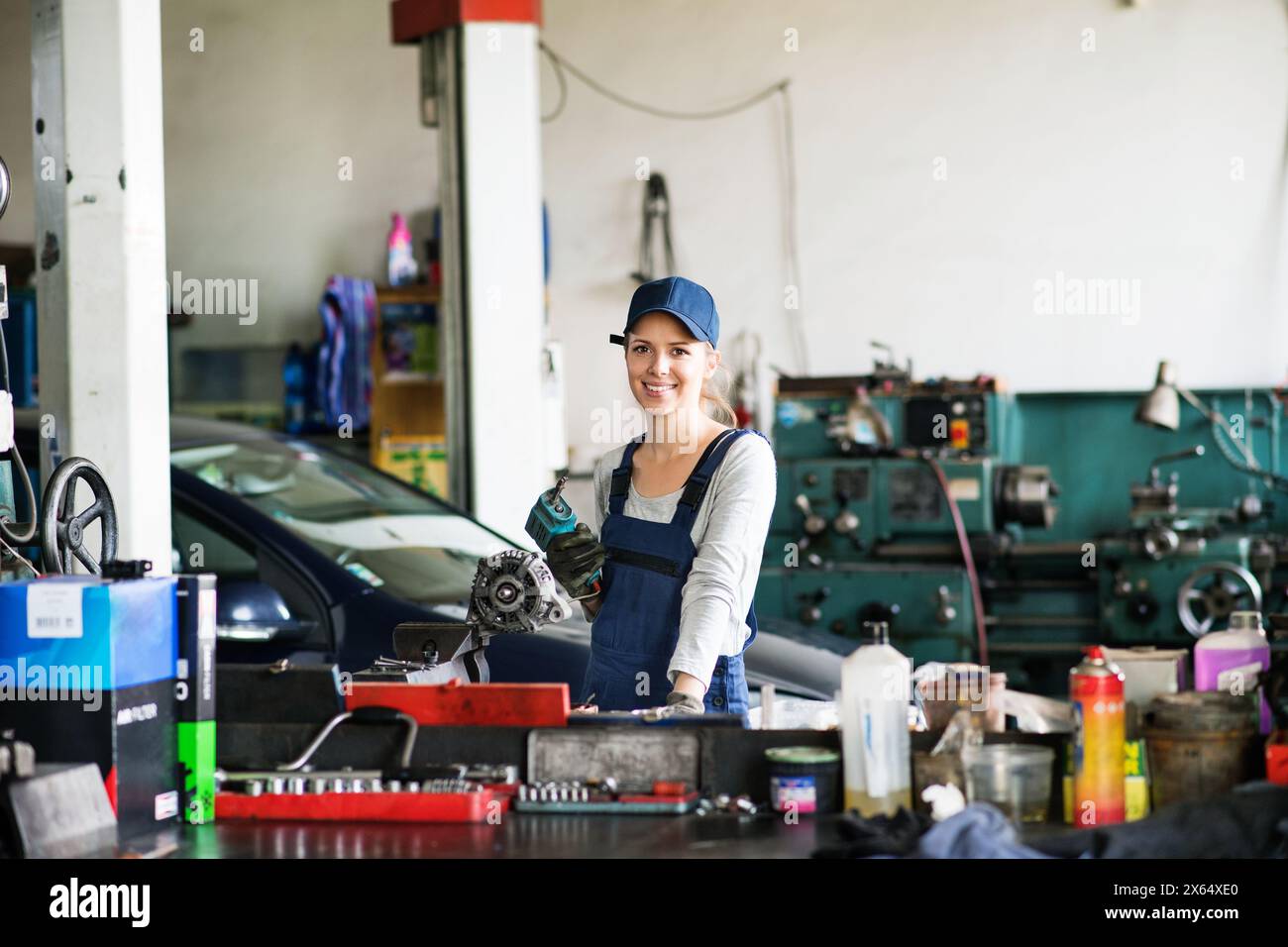 Female auto mechanic repairing, maintaining car. Beautiful woman ...