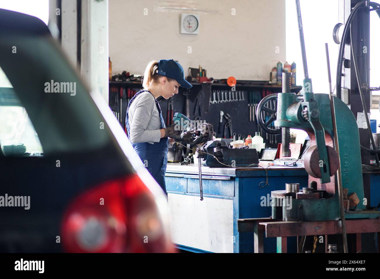 Female auto mechanic repairing, maintaining car. Beautiful woman ...