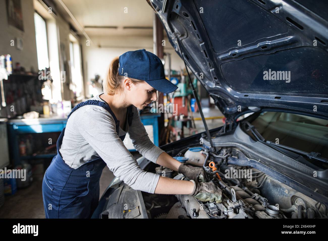 Female auto mechanic repairing, maintaining car. Beautiful woman ...