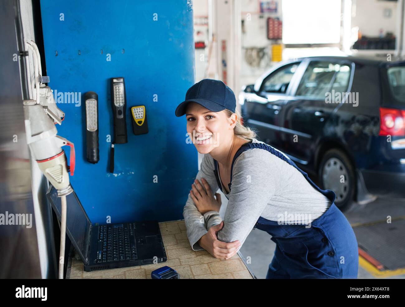 Female auto mechanic repairing, maintaining car. Beautiful woman ...