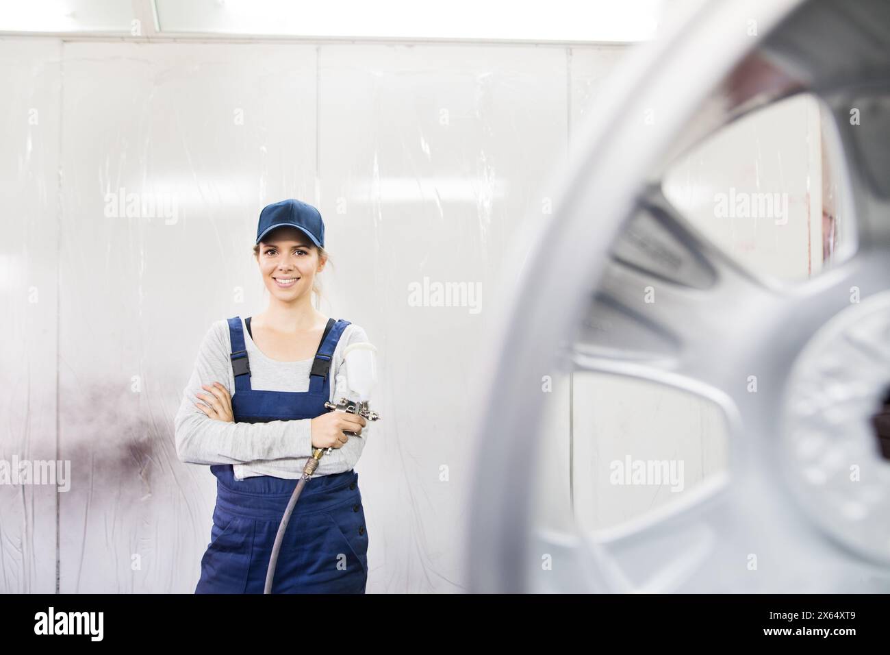Female car painter, paingting vehicles in auto body shop. Young woman ...