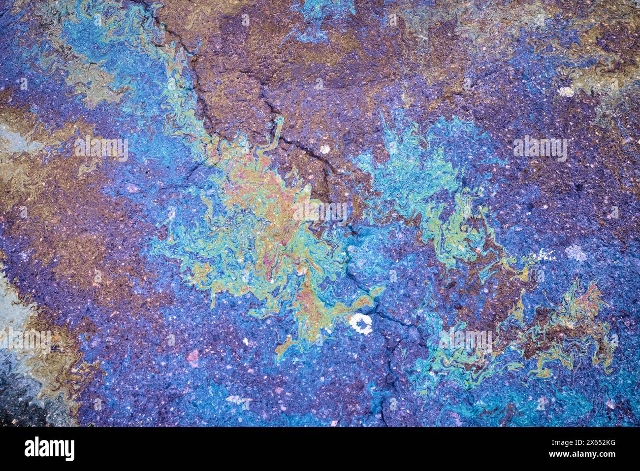 Texture of colorful petrol oil spill on wet pavement Slick industry oil ...