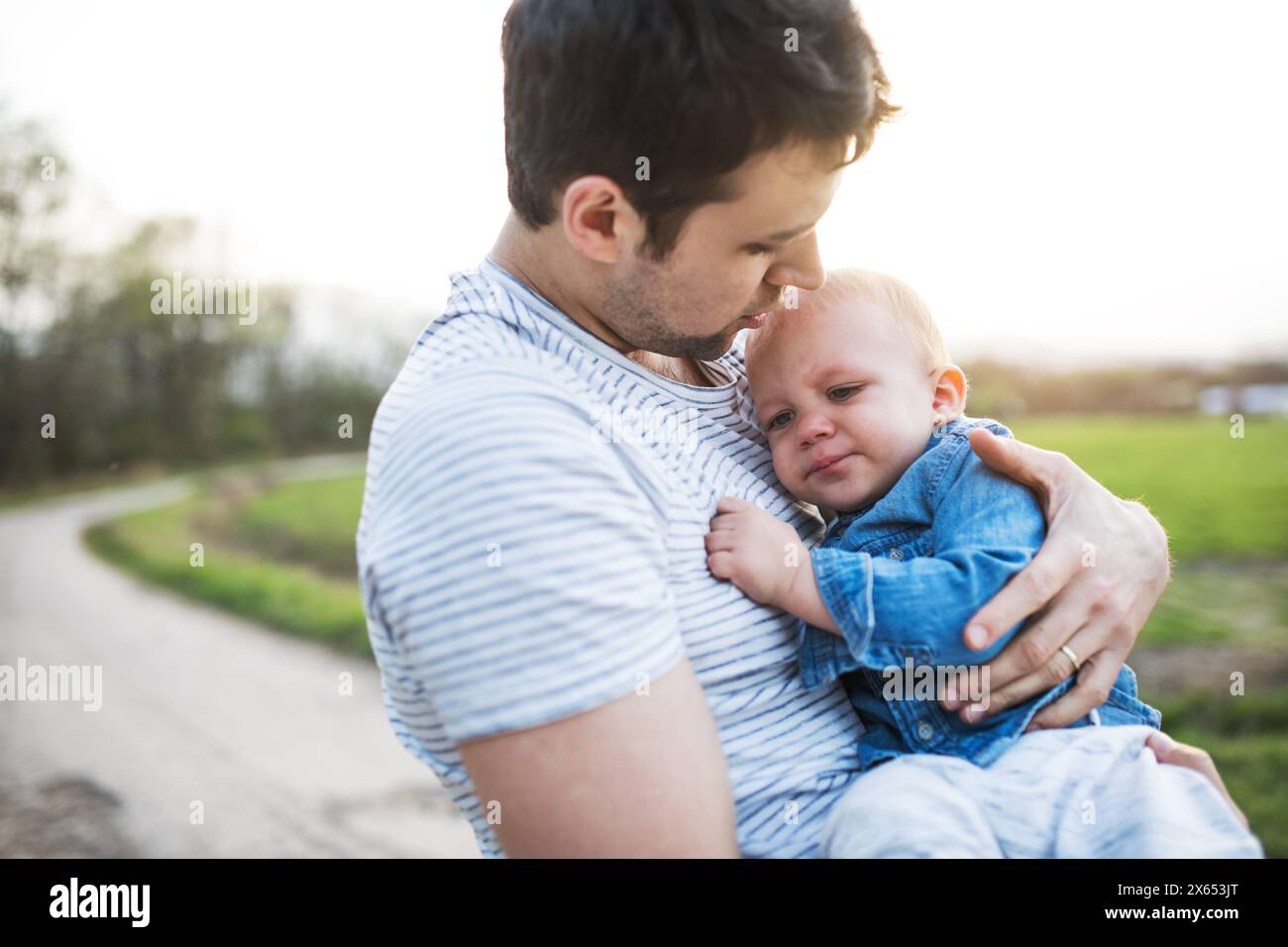 Father holding crying little toddler in arms, soothing him. Father's day concept Stock Photo - Alamy