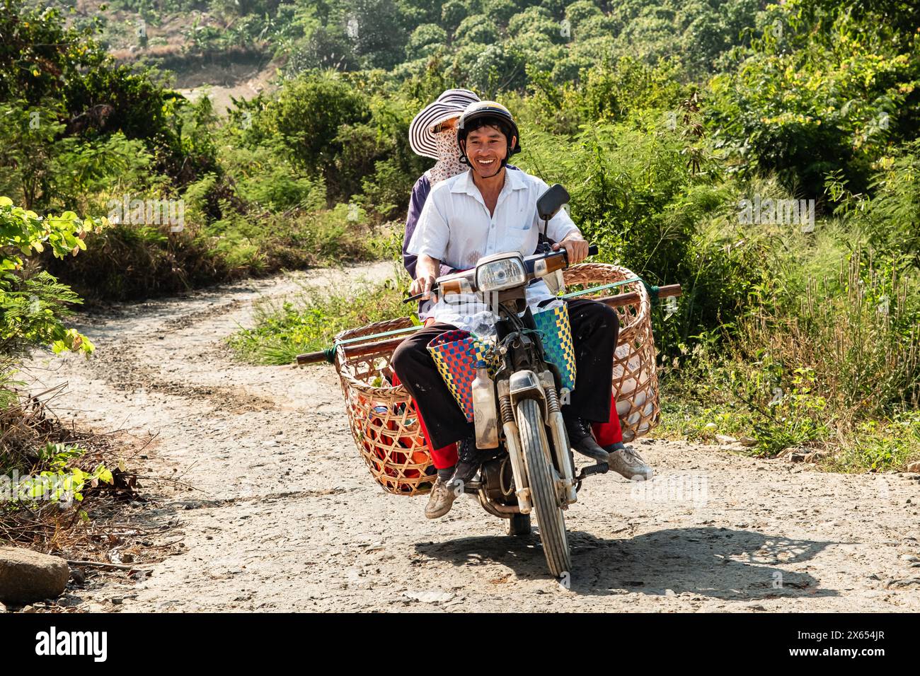 Asian couple is driving on a motorbike back home from a city to their ...