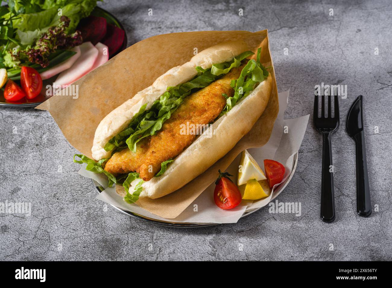 Fried fish sandwich with greens on the stone table. Turkish name Balik ...