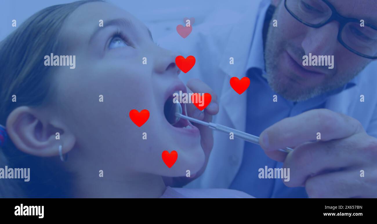 Image of heart icons over caucasian male dentist treating caucasian ...