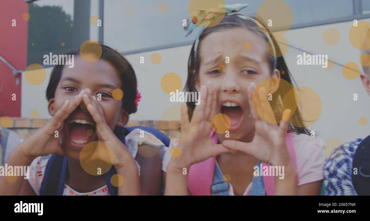Image of orange circles over happy diverse schoolchildren having fun ...