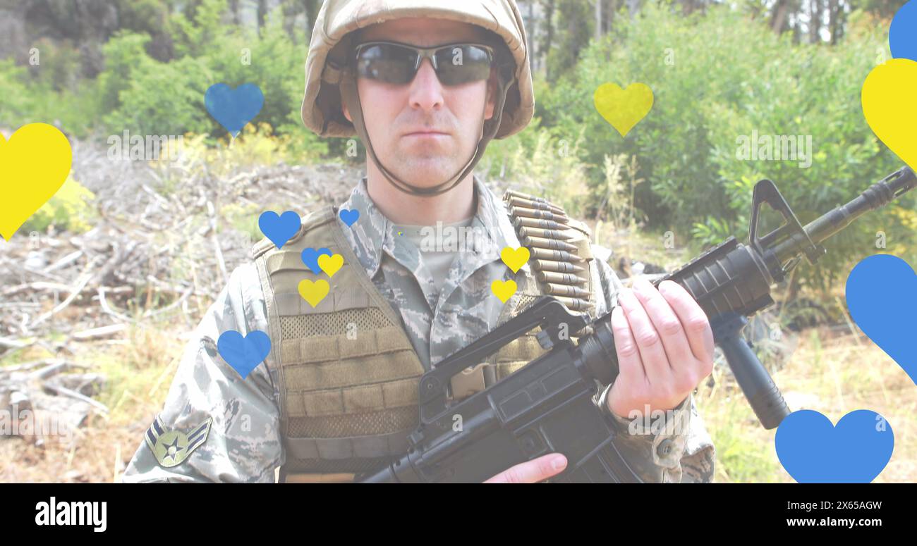 Image of yellow and blue hearts over caucasian male soldier with weapon ...